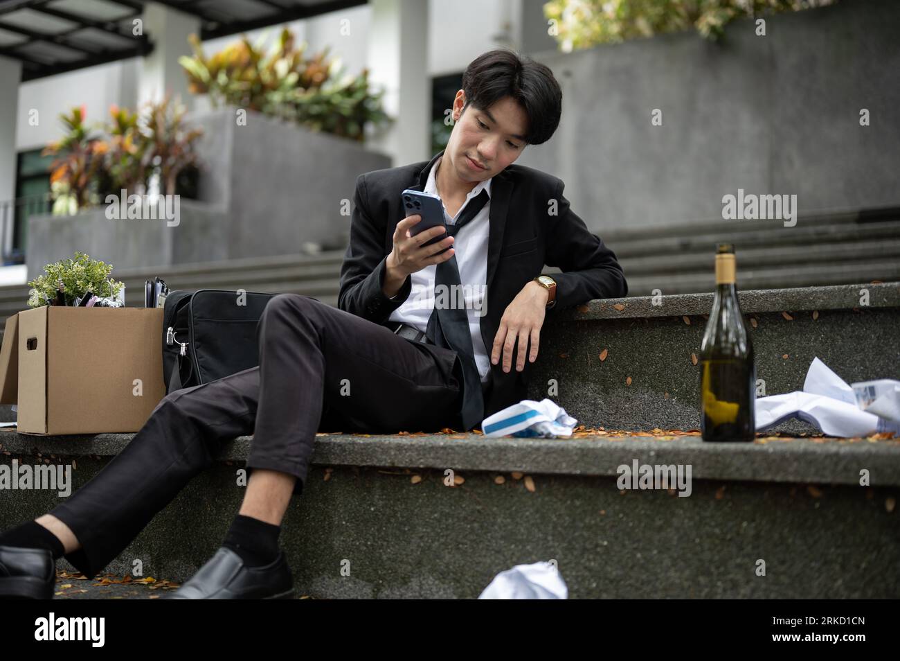 A drunk and hopeless Asian unemployed businessman is typing on his ...