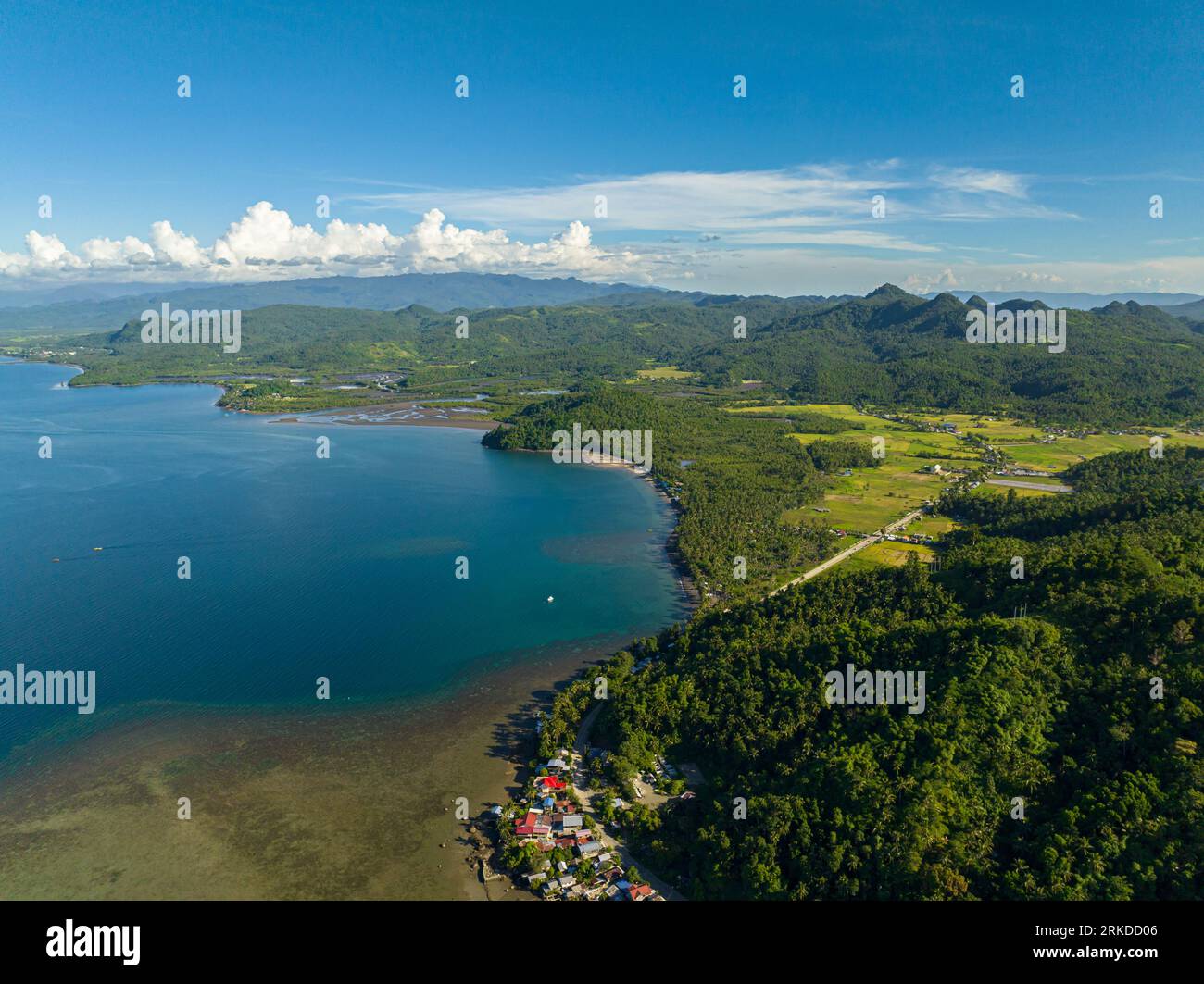 Tropical landscape of coastline with small village and blue sea ...
