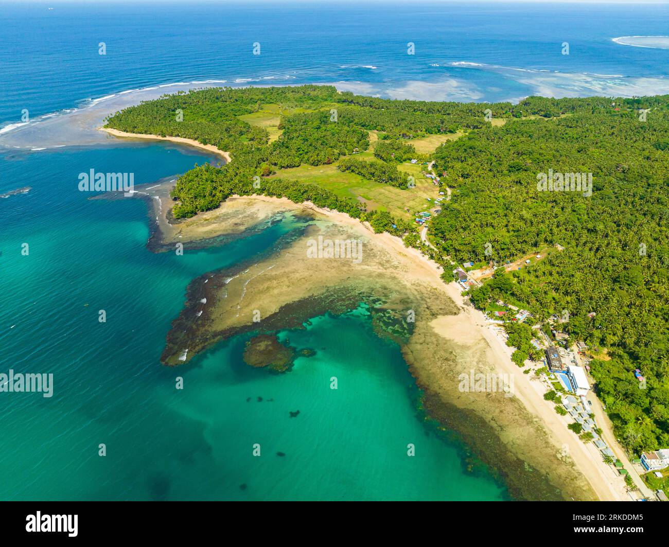 Tropical island with white sand shoreline and the deep blue sea ...