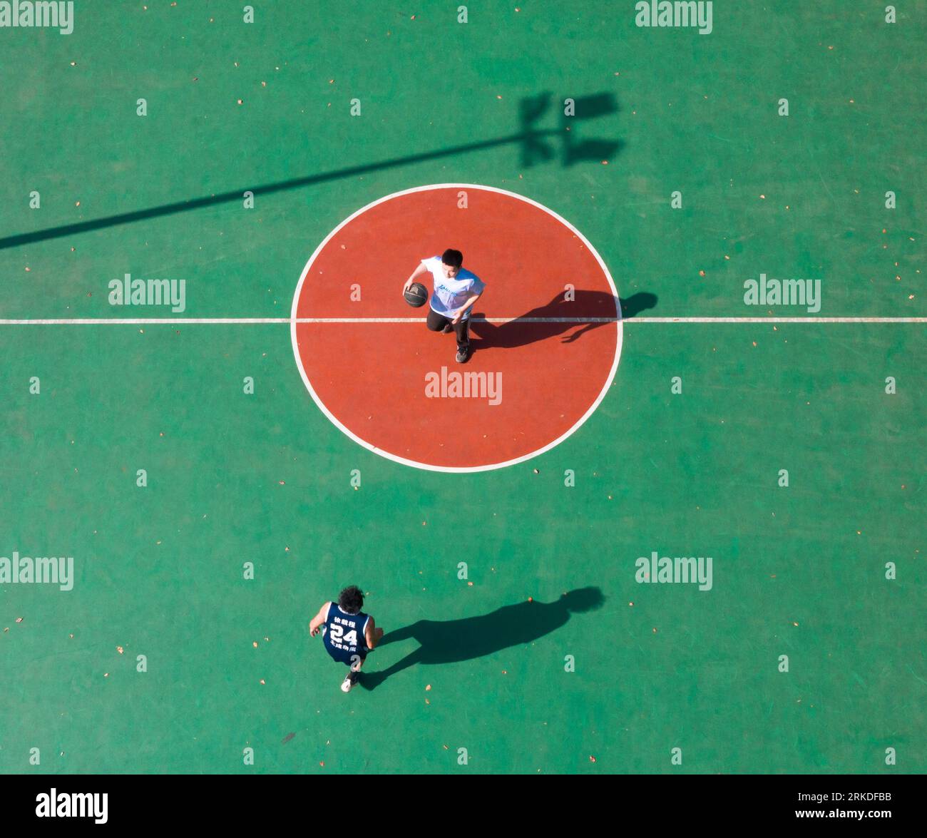 An aerial view of two men playing basketball on an outdoor basketball ...