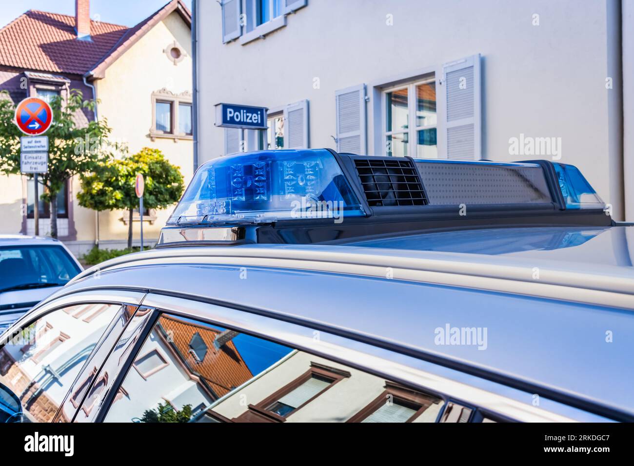 German police car on the street, detail of blue siren flasher. Parking at police station ...