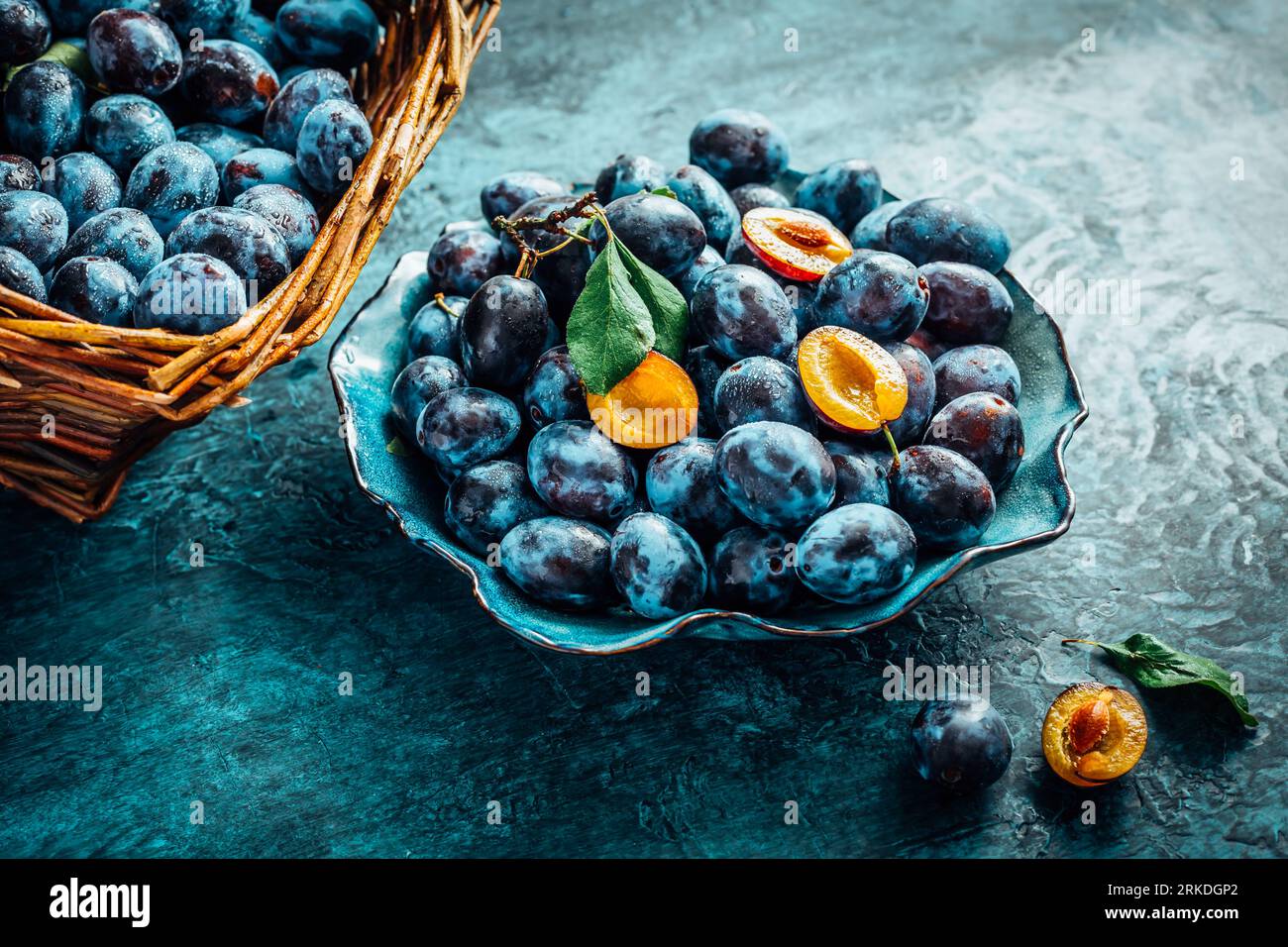 Freshly picked plums in a bowl and basket. Organic food and harvesting ...
