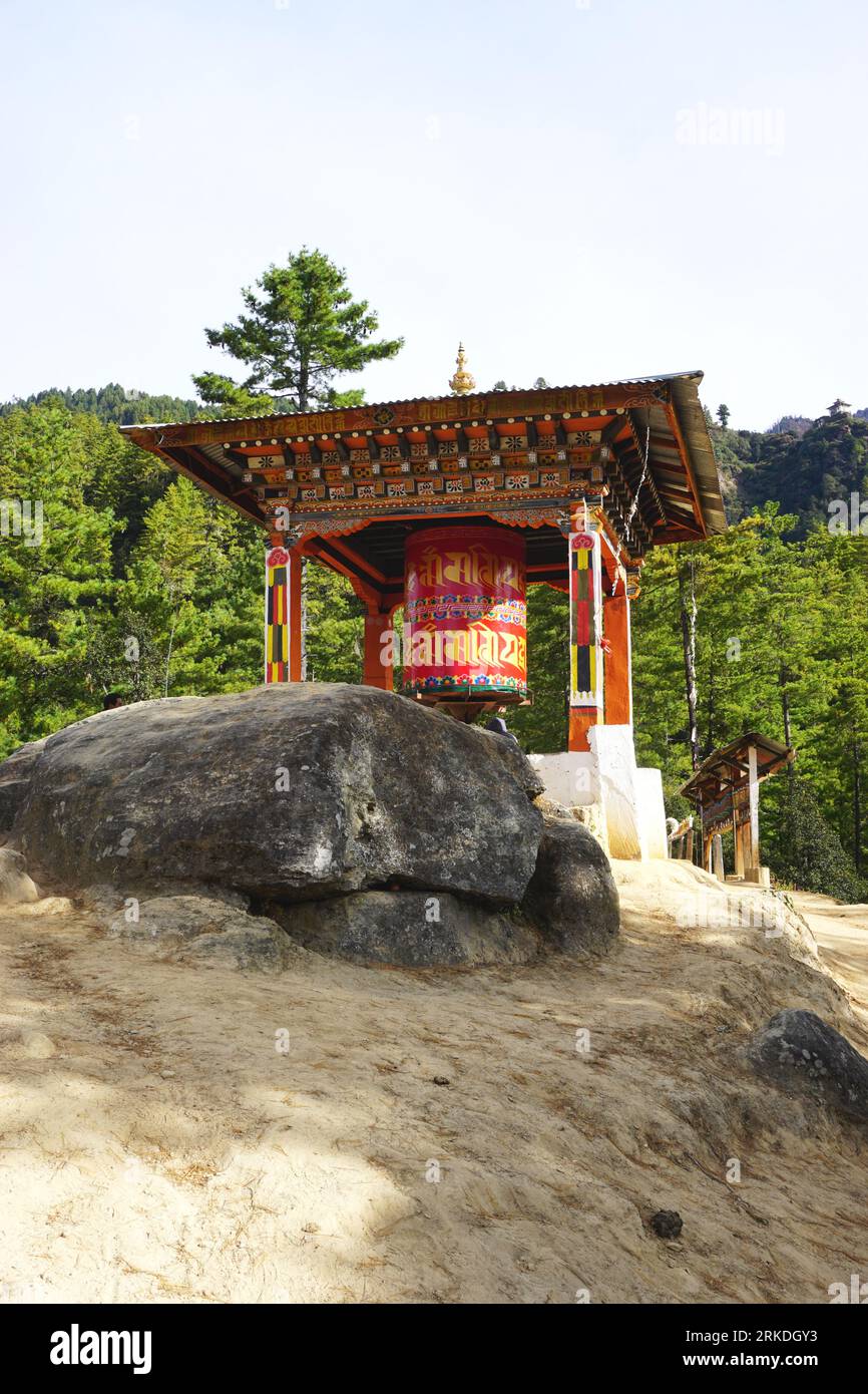 A colorful traditional Bhutanese painted pagoda shelters a huge prayer ...