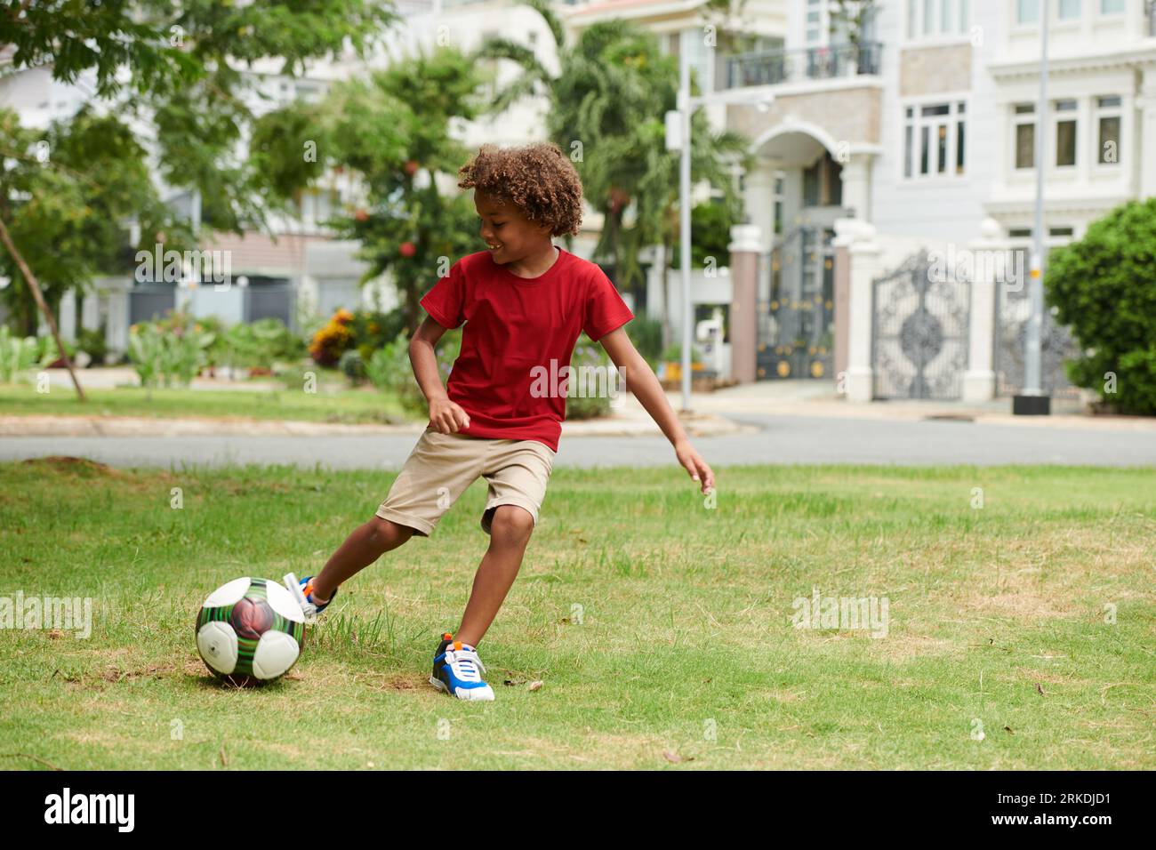 Talented active kid playing soccer on backyard Stock Photo - Alamy