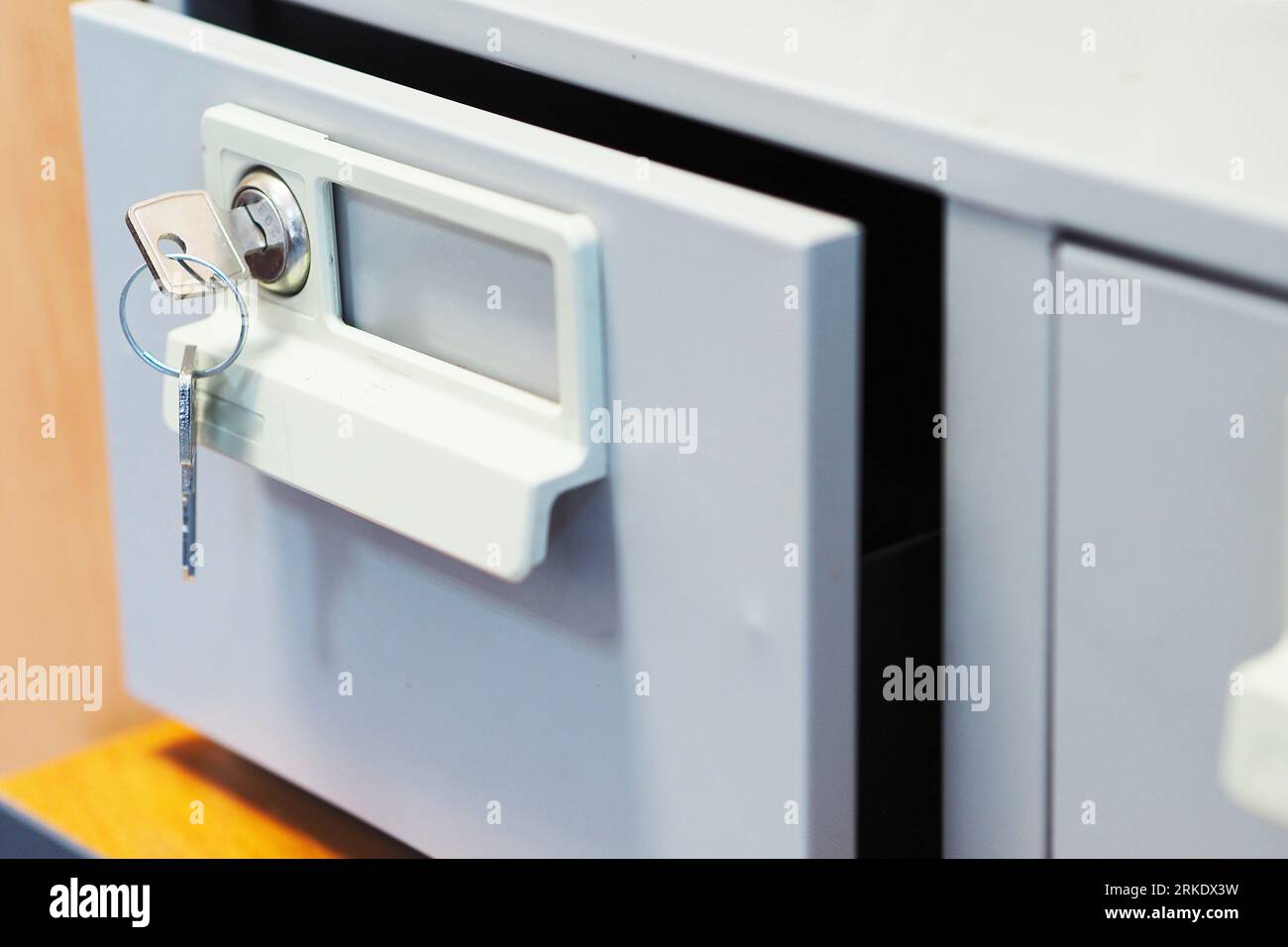 It is open gray document box with key in lock. Open cell drawer with ...
