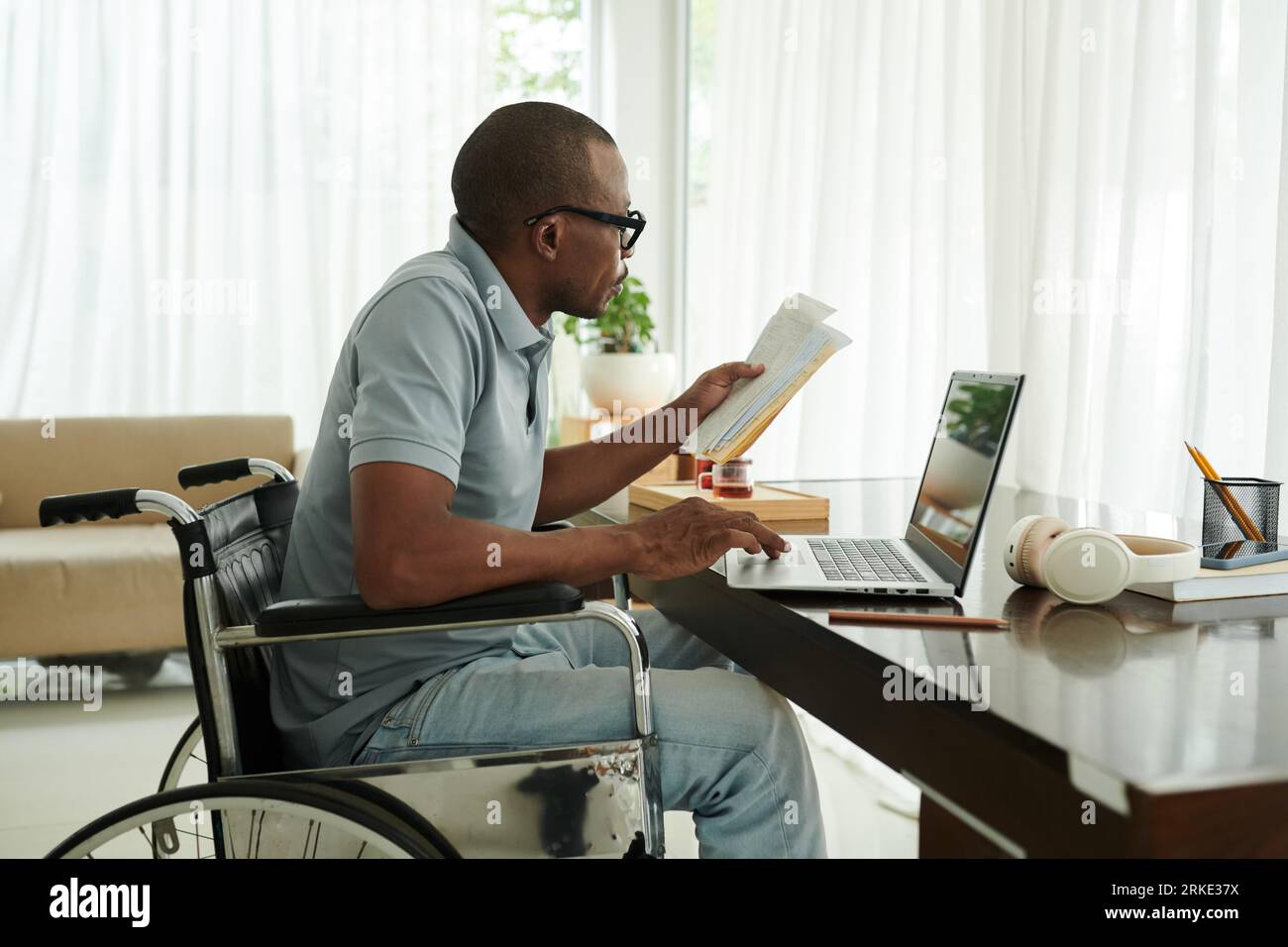 Man with disability checking his medical documents and filling form on ...