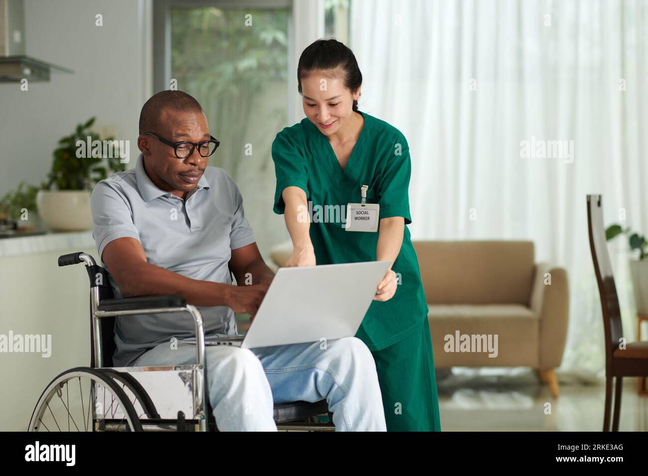 Social worker explaining patient with disability how to use ...