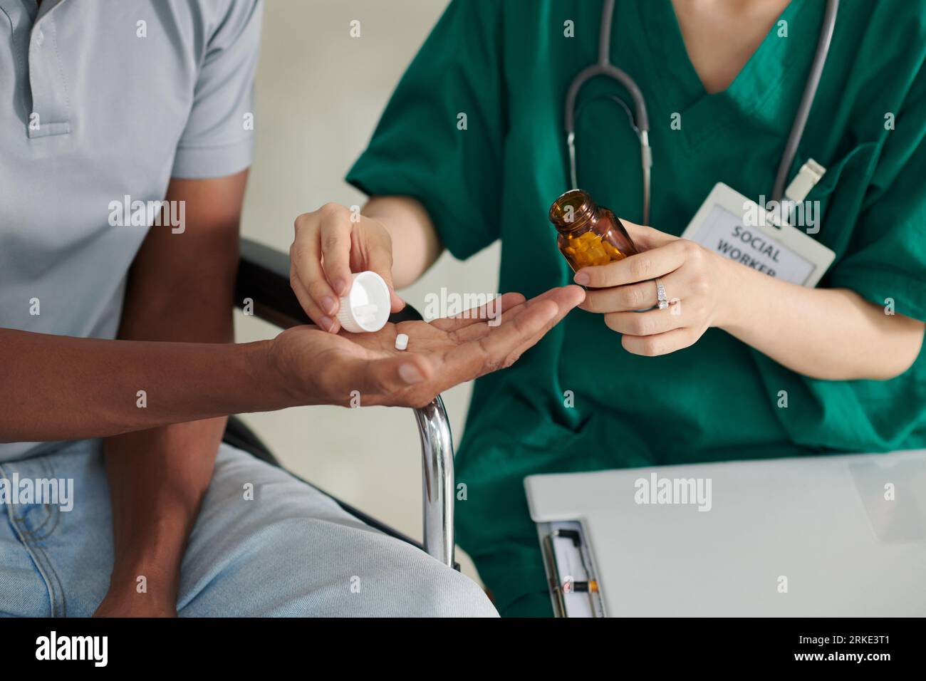 Social working giving patient daily dose of supplements Stock Photo - Alamy