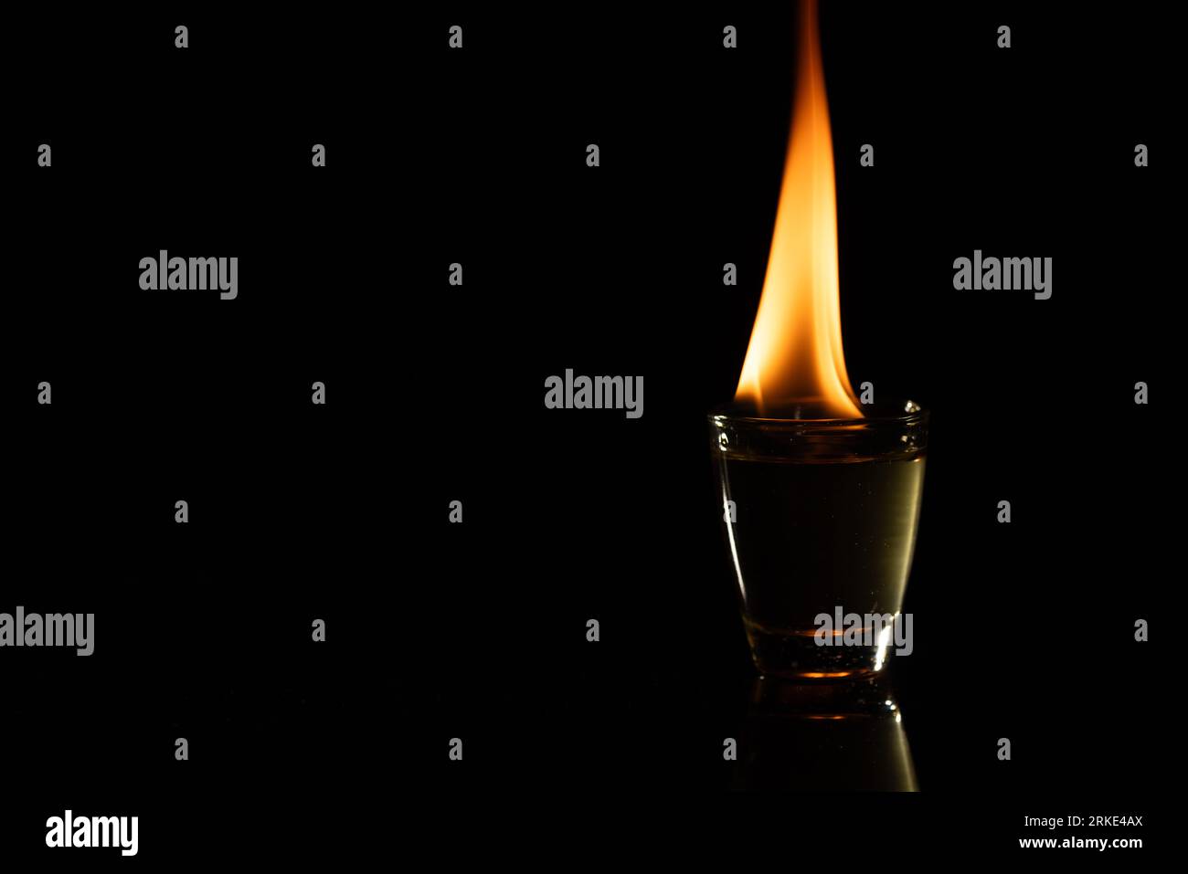 Lit candle in glass container with copy space on black background Stock ...