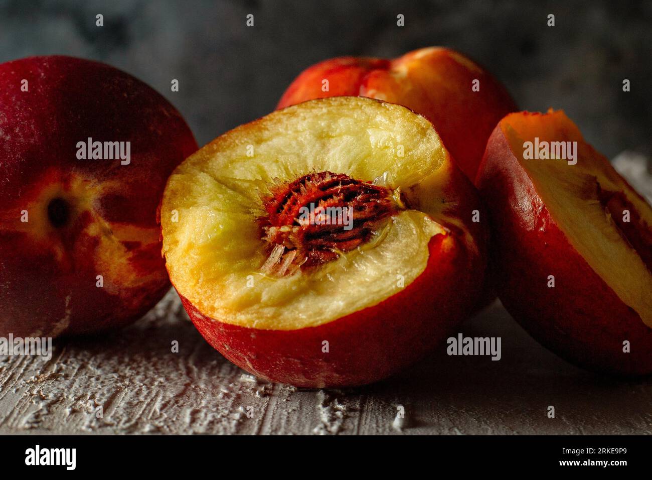 Broken nectarine on a rustic background. The fruits of summer. Three ...