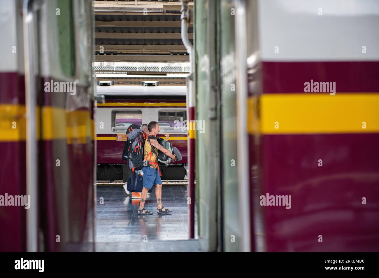 Bangkok, Thailand: Two backpacker travelers walking through the platform at Bangkok Railway ...