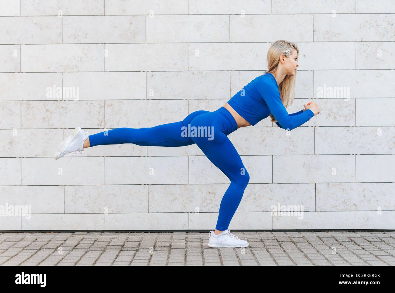 Fitness sport woman doing stretching exercise over gray wall ...
