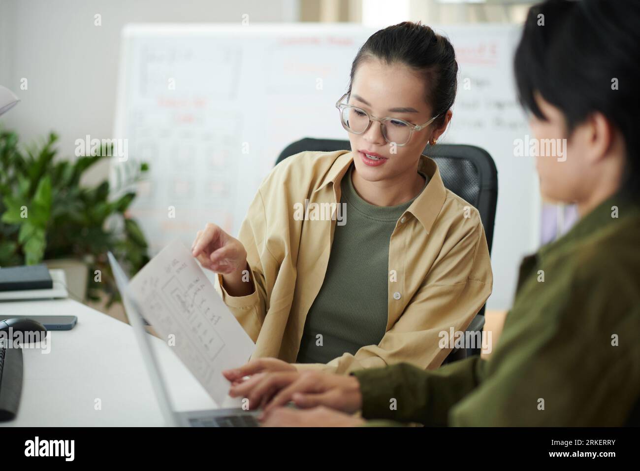 UI designer showing sketch of wireframe to front end developer Stock Photo - Alamy