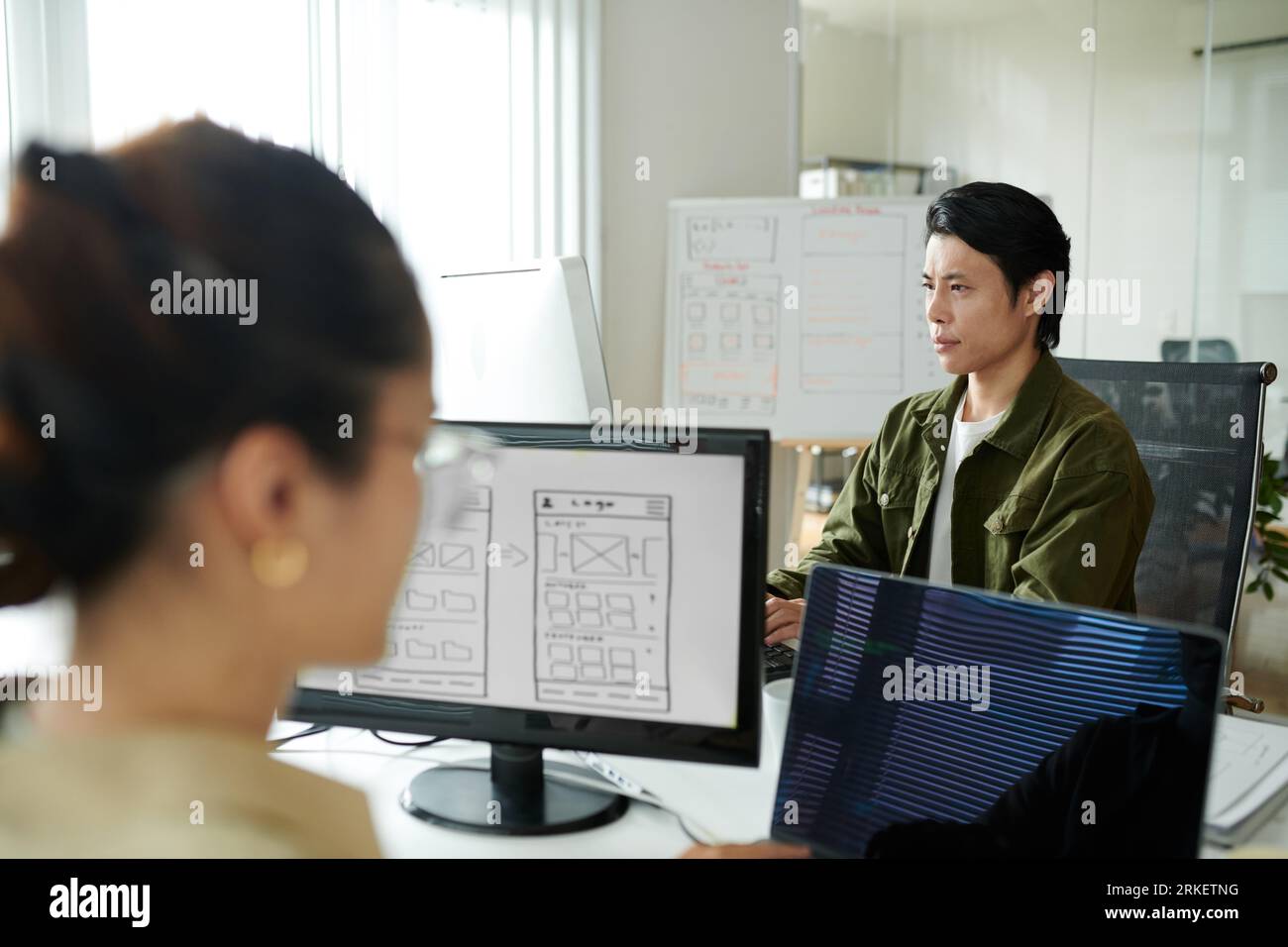 Serious team leader reviewing programming code of junior coworker Stock ... Serious team leader reviewing programming code of junior coworker Stock ...