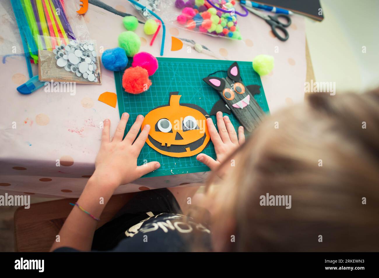 Caucasian child girl preparing cardboard Halloween decorations and ...