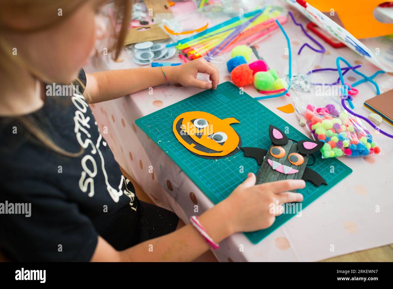 Caucasian child girl preparing cardboard Halloween decorations and ...