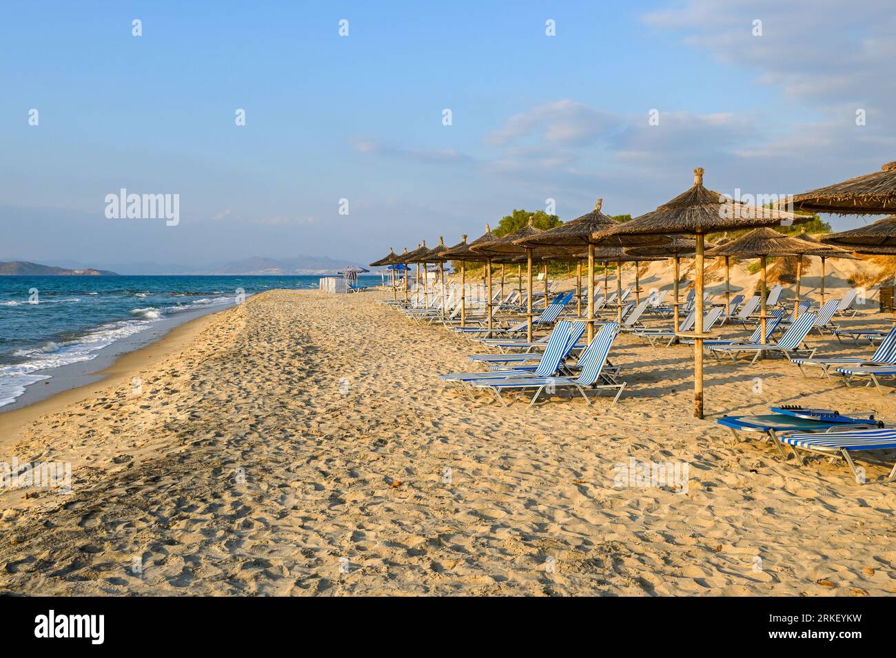 Sunbeds with umbrella on sandy beach of Marmari. The Greek island of ...