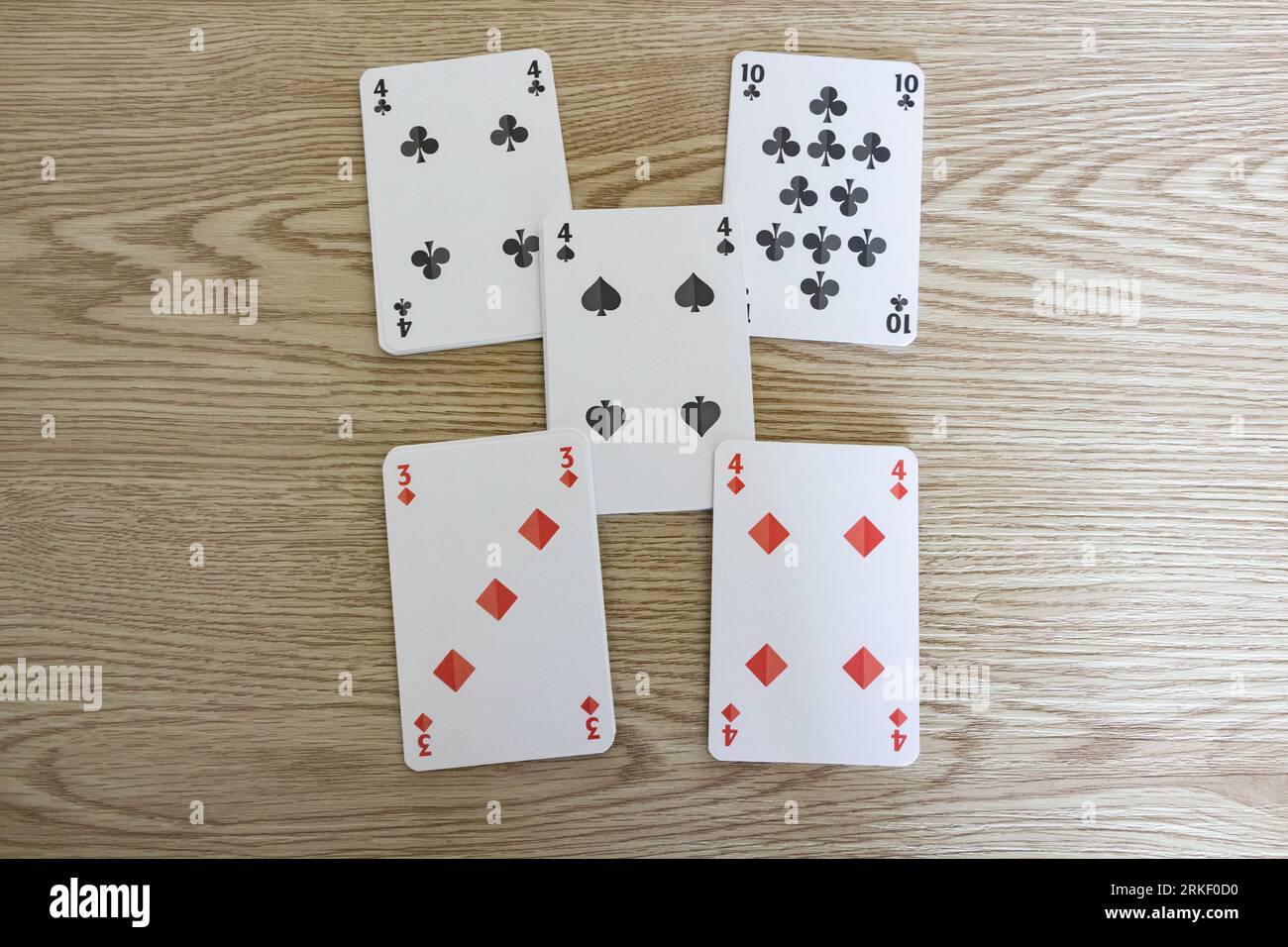 Five playing cards spread on wooden background Stock Photo - Alamy