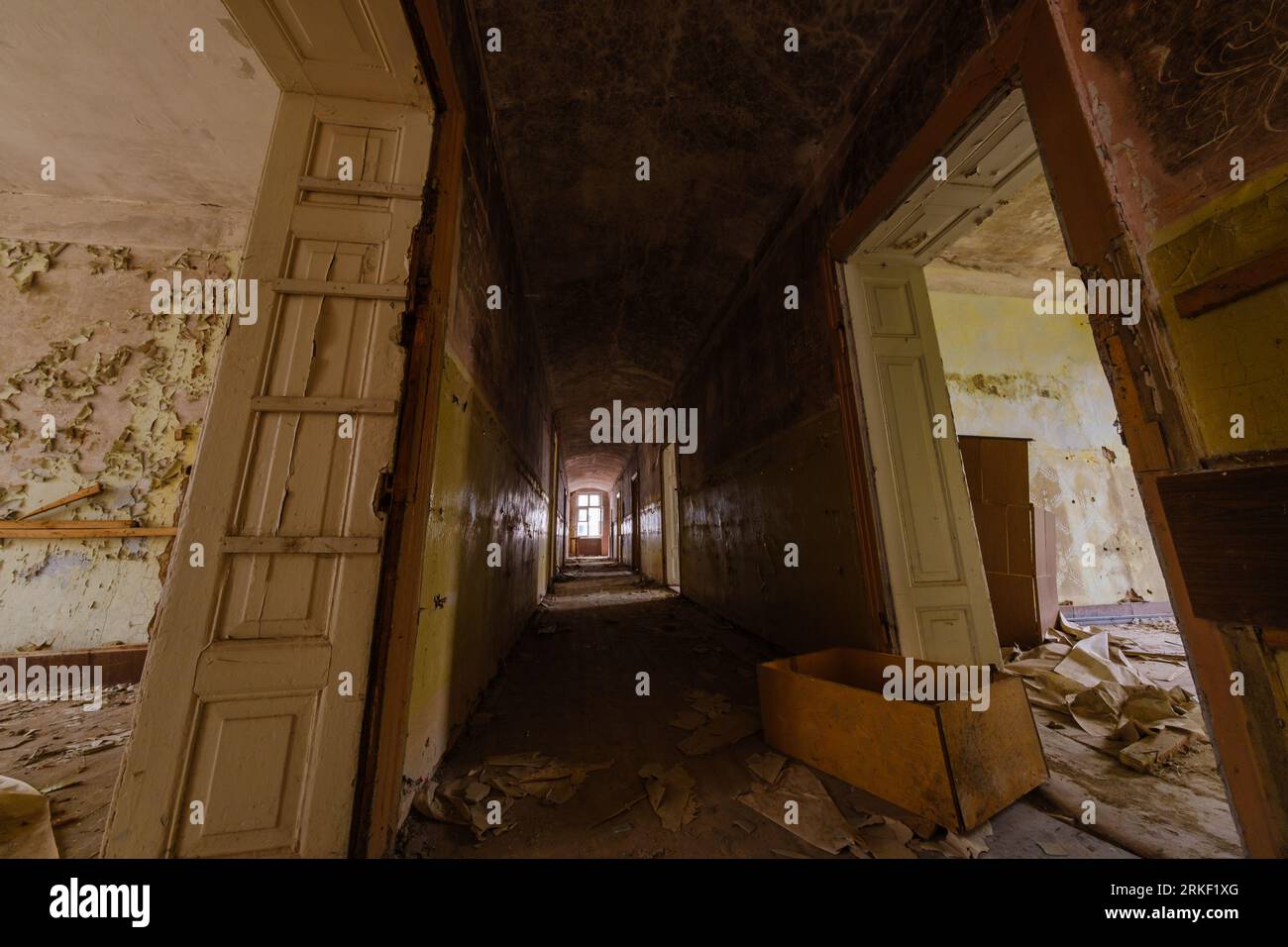Corridor with white and green shabby walls and big doorways inside old abandoned destroyed ...
