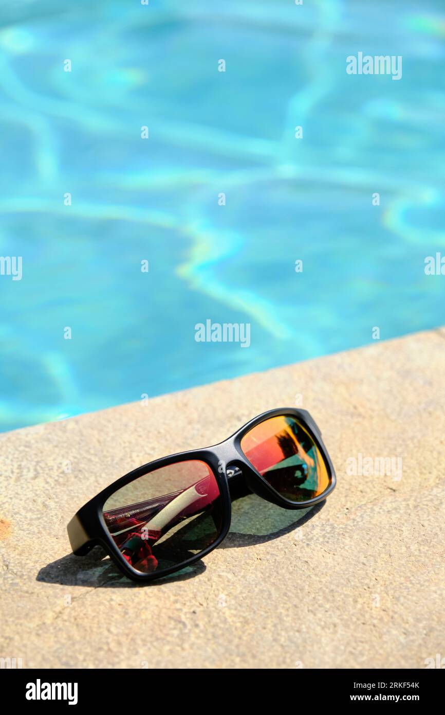sunglasses on the background of the pool Stock Photo - Alamy