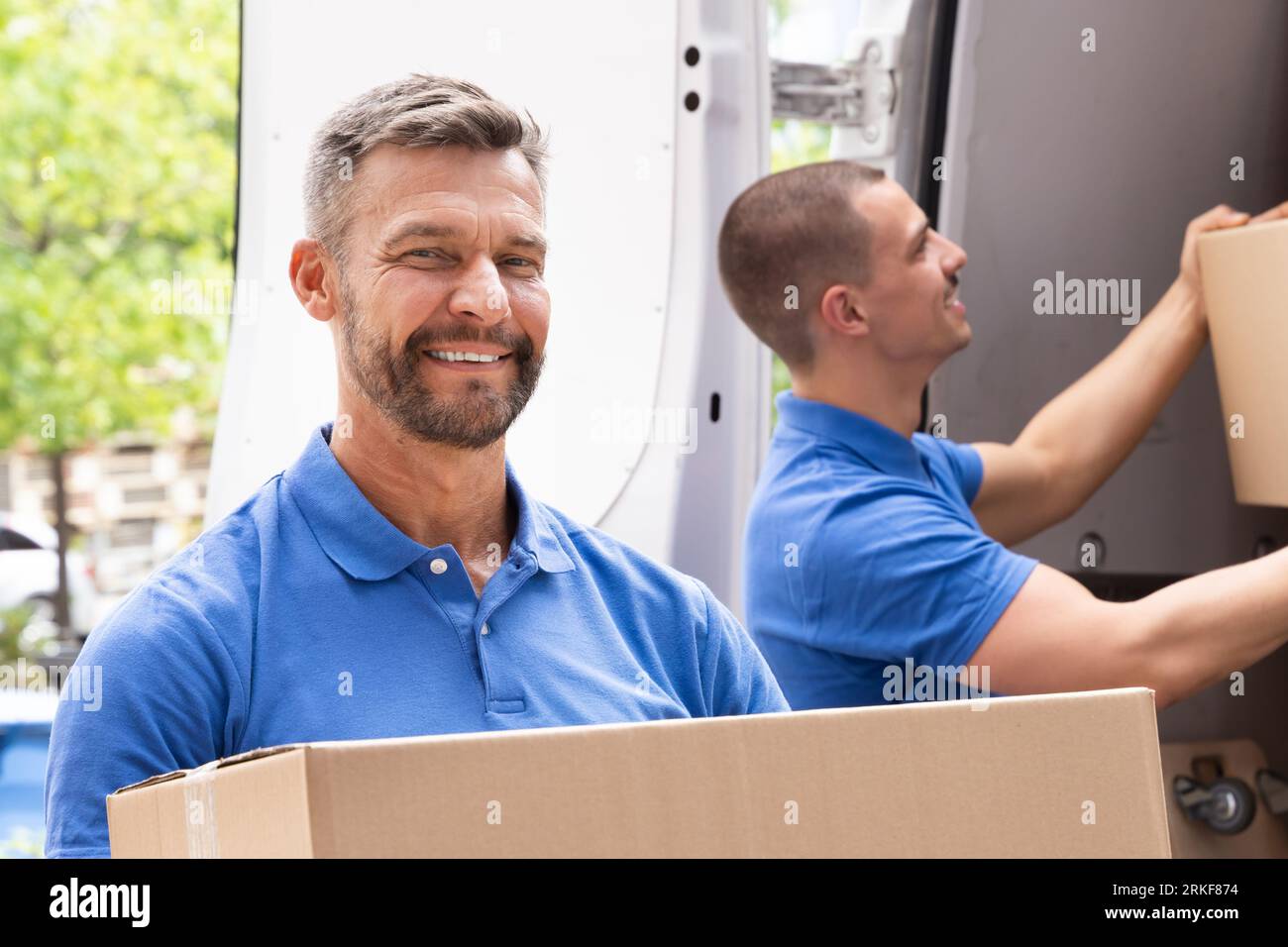 Truck Movers Loading Van Carrying Boxes And Moving House Stock Photo ...