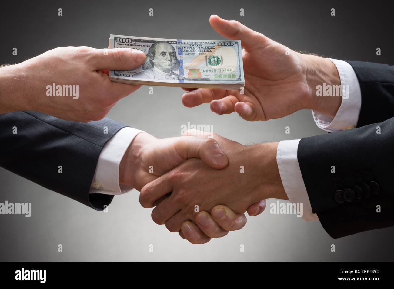 Businessmen money shake hands hi-res stock photography and images - Alamy