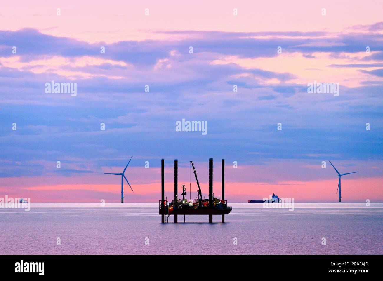 Drilling test rig amid windfarm turbines and rig support ships off the ...