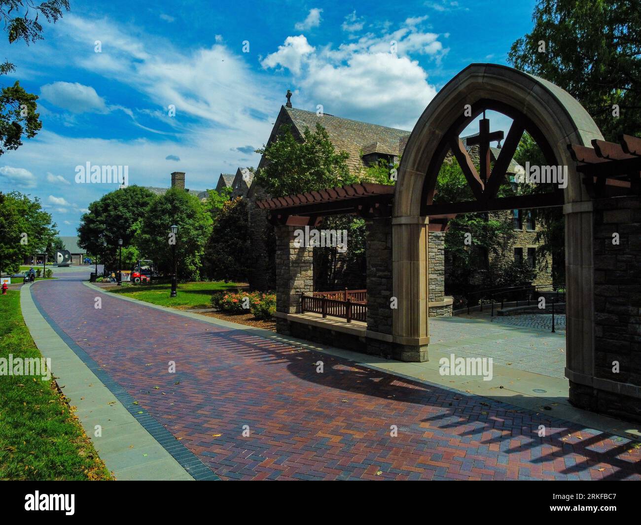 A pathway lined with green trees near a church entrance Stock Photo - Alamy