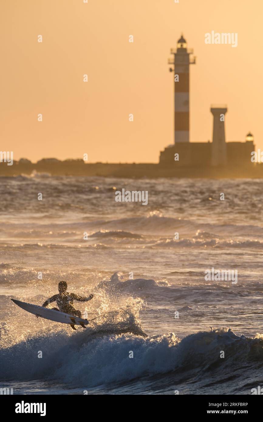 Surfing at the lighthouse Stock Photo - Alamy