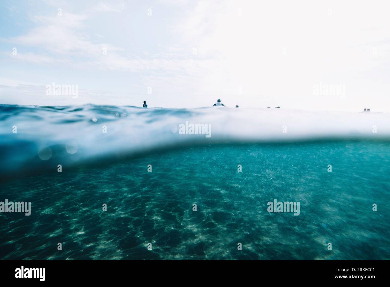 Pulled back over under of surfers waiting sitting on surfboard Stock ...