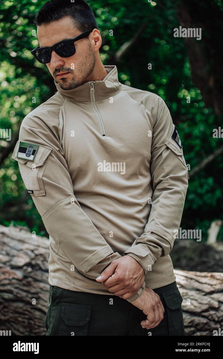 An attractive middle-aged male posing in a military outfit in a forest ...