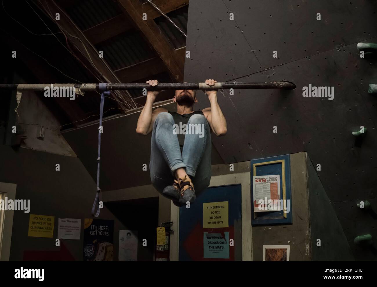 Strong male doing pull ups on a bar next to a climbing wall Stock Photo ...