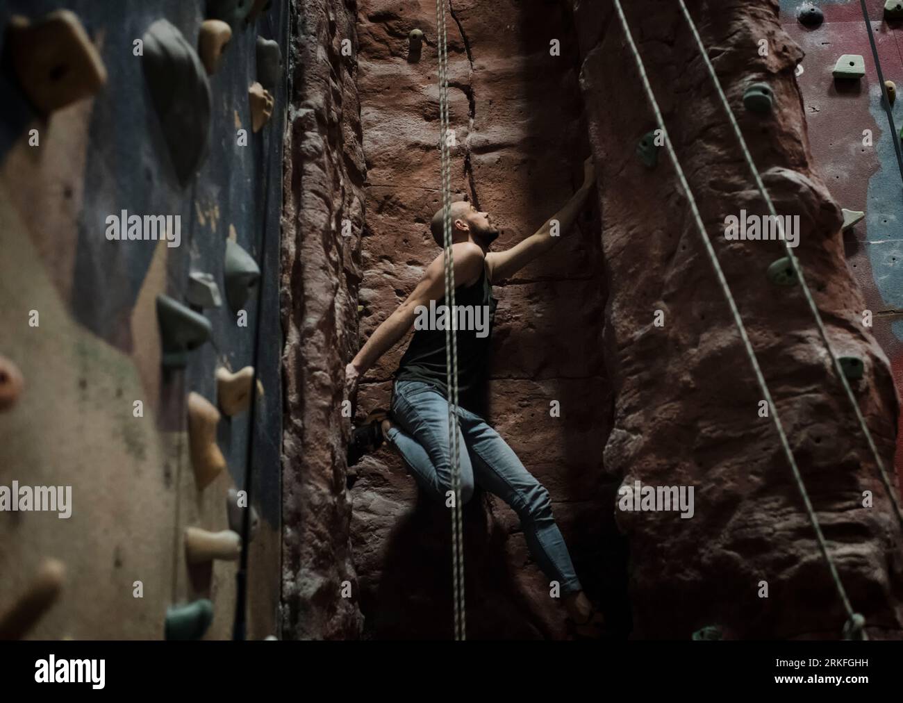 strong man free climbing between two walls Stock Photo - Alamy
