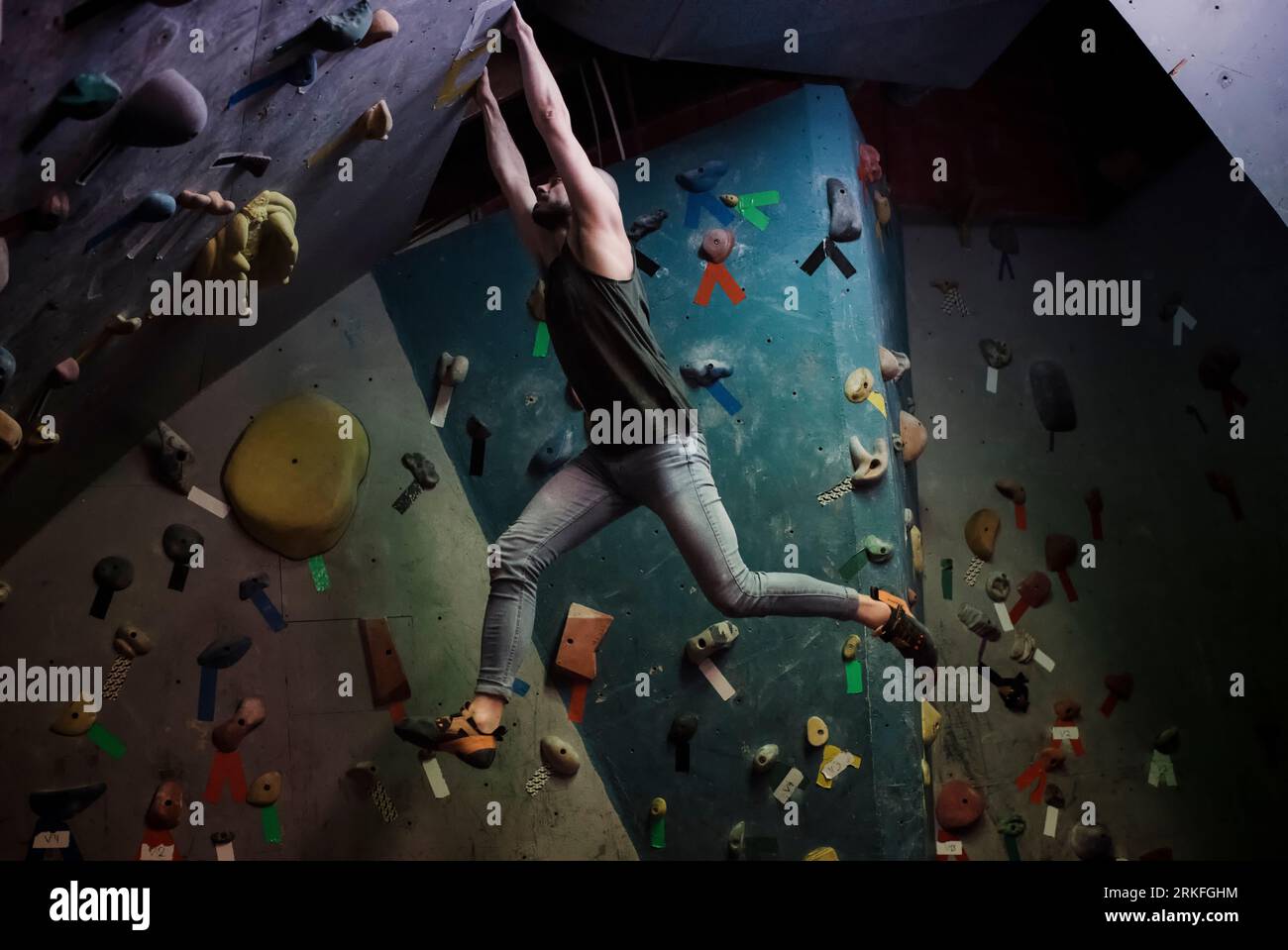 Strong man bouldering, free climbing indoors Stock Photo - Alamy