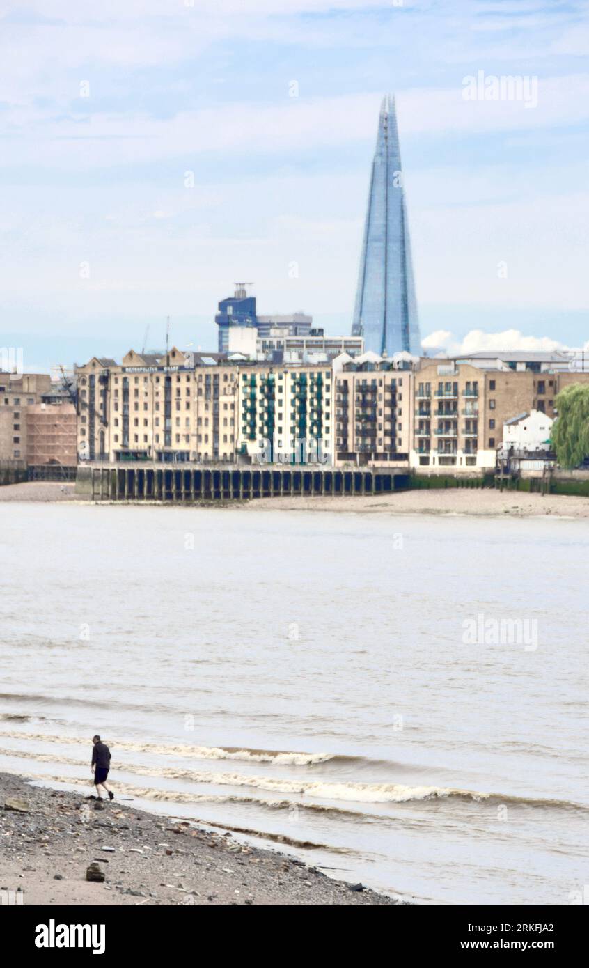 man walking on beach and iconic Shark architecture London bridge Stock ...