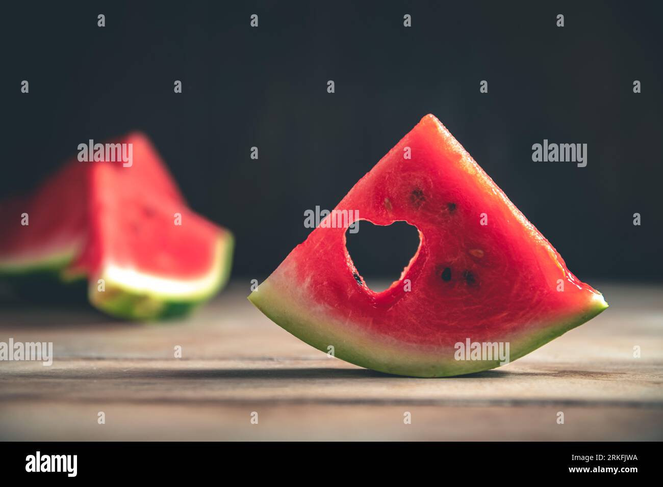 A cut piece of watermelon with a heart-shaped hole. concept Summer, joy ...