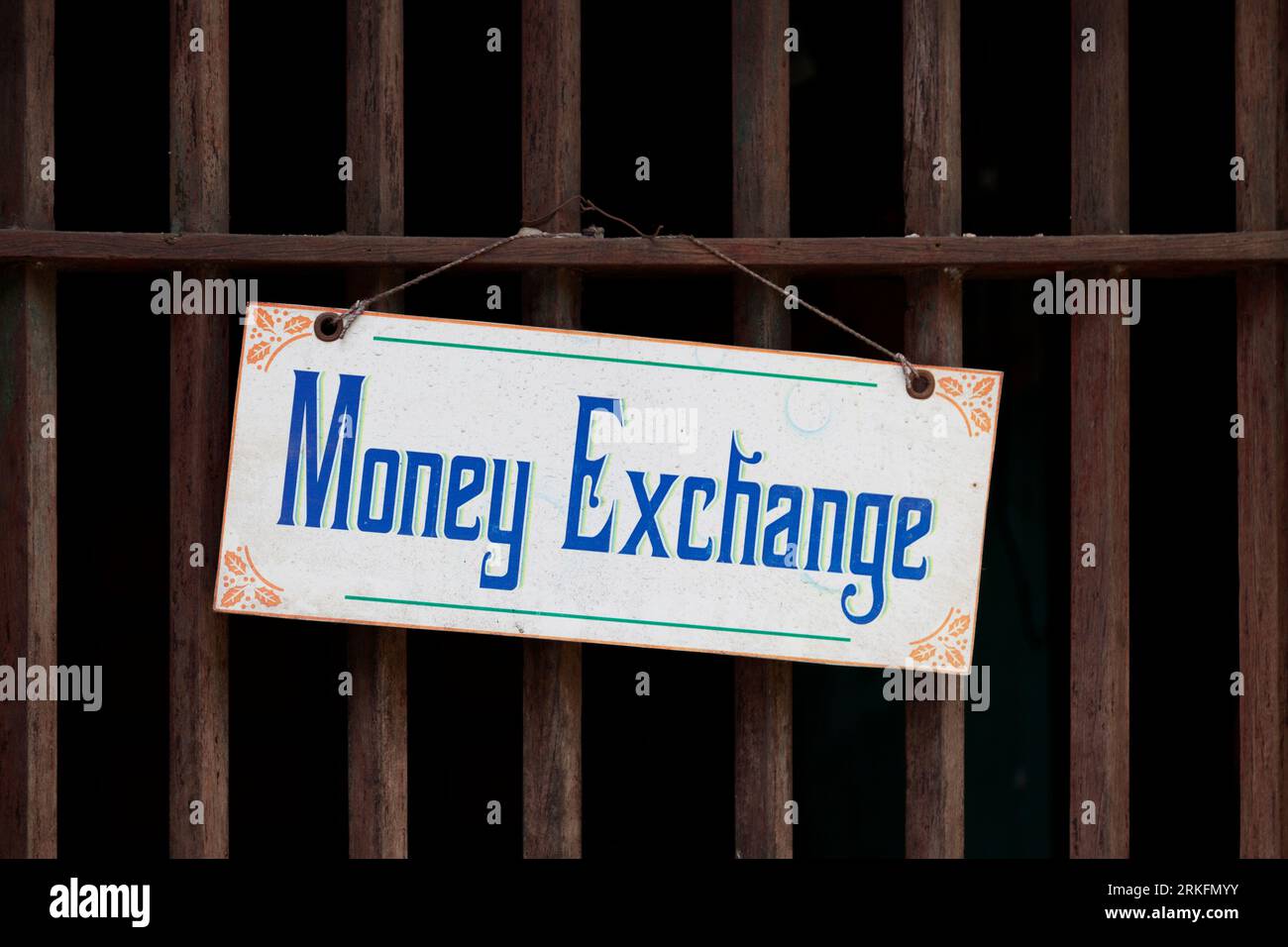 White sign hanging from the bars of a window saying "Money Exchange ...