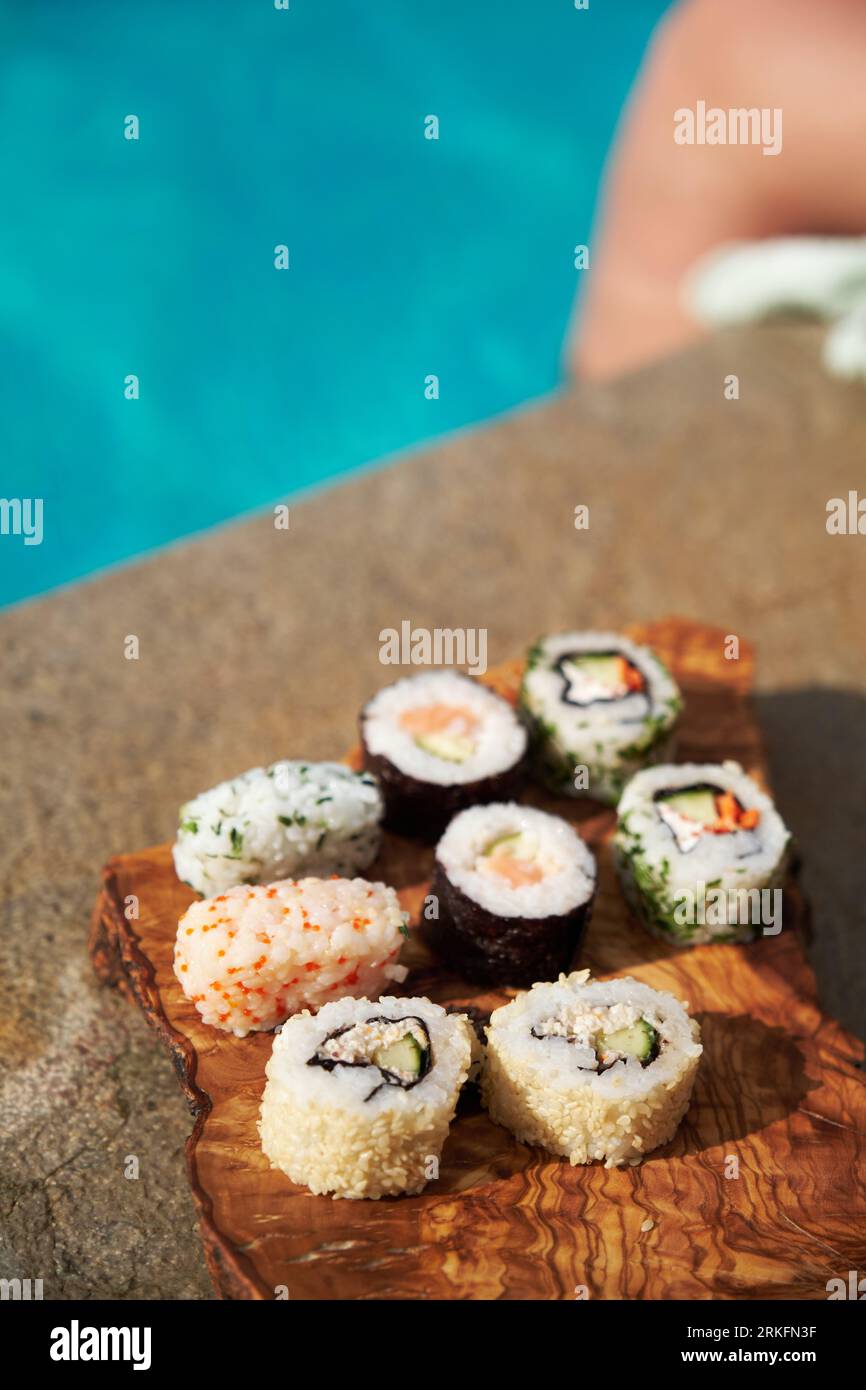 assorted sushi on a board near the pool Stock Photo - Alamy