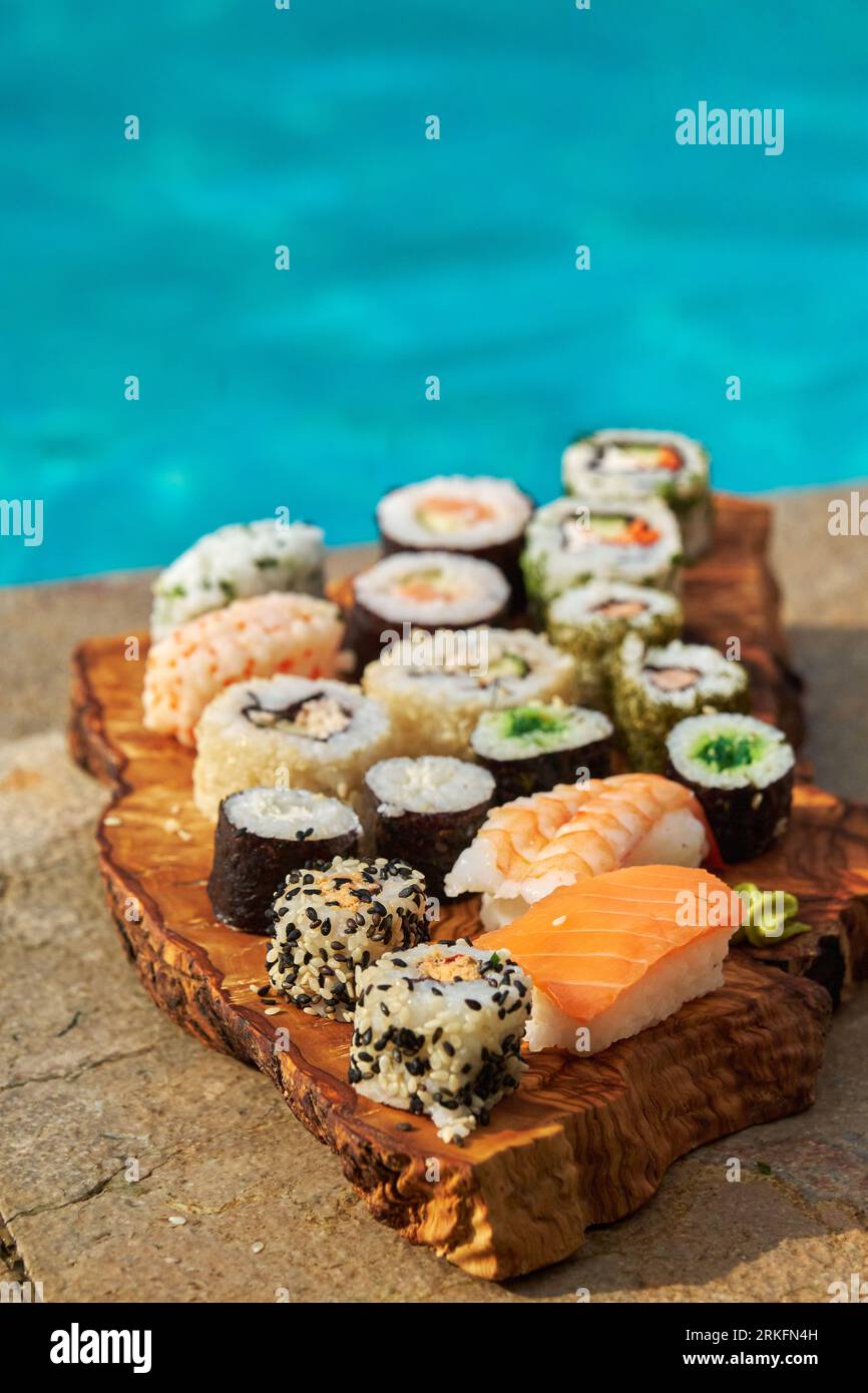assorted sushi on a board near the pool Stock Photo - Alamy