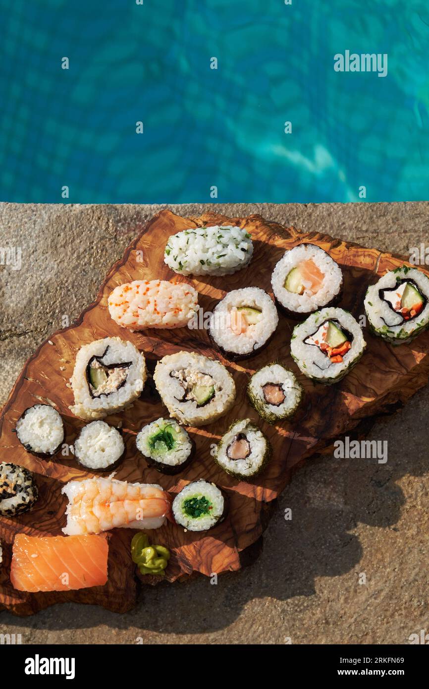 assorted sushi on a board near the pool Stock Photo - Alamy