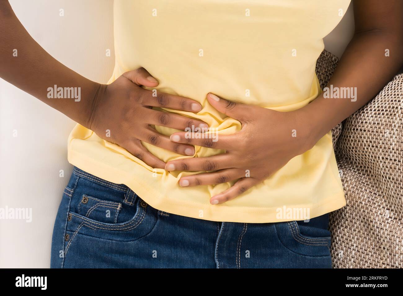 Young African Woman Lying On Sofa Suffering From Stomach Ache Stock ...