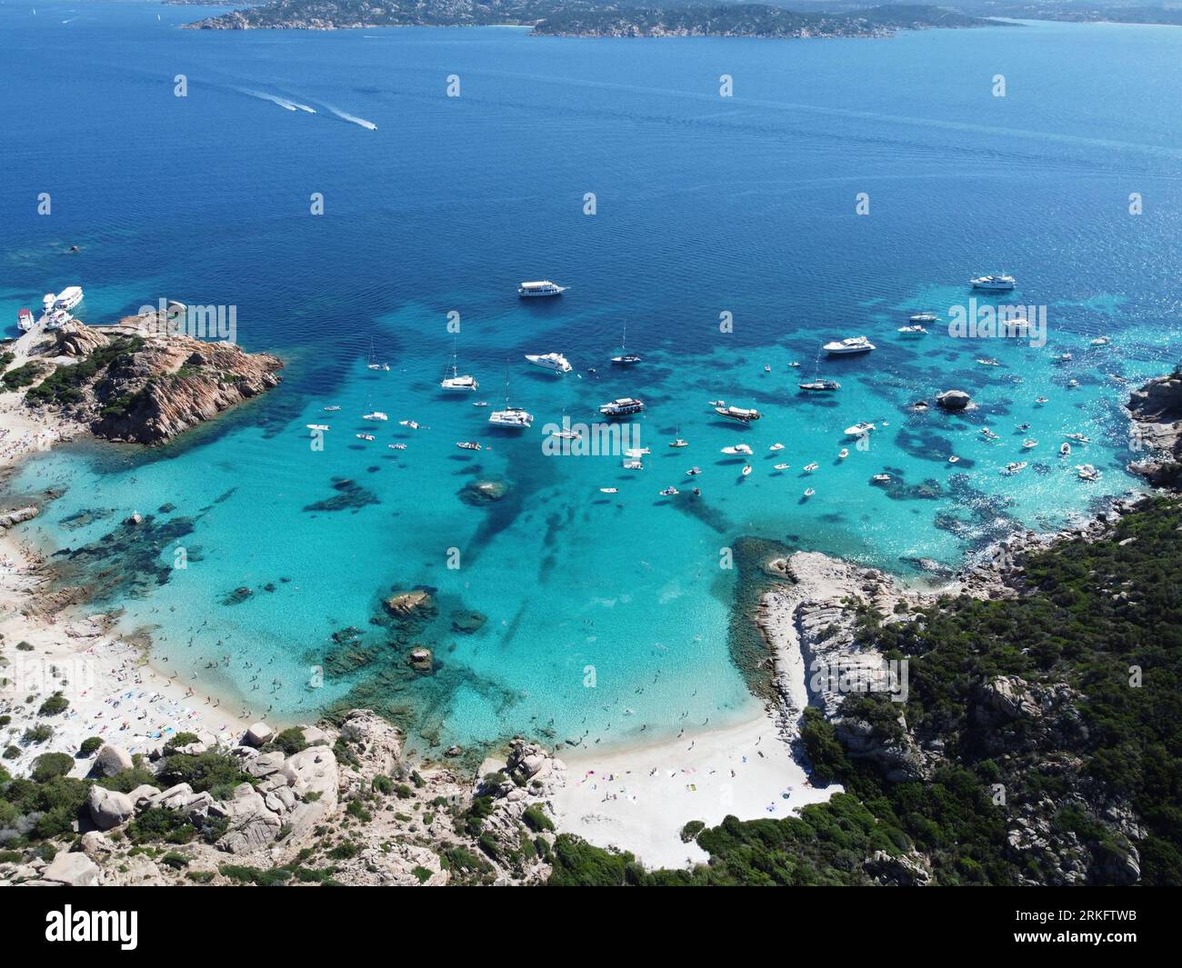 A picturesque beach with a line of boats moored at the water's edge in ...