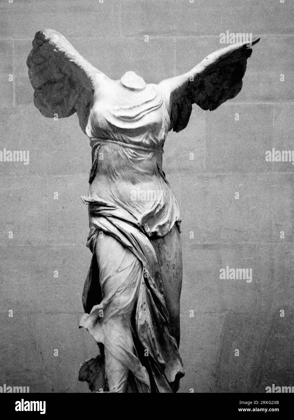 An antiquated female sculpture with its wings expanded upwards in a ...