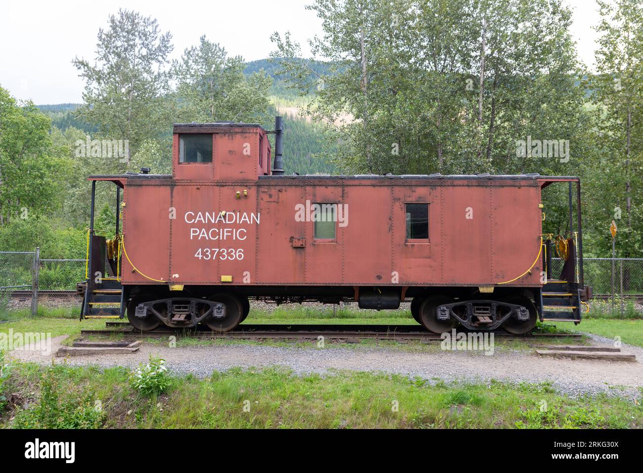 A vintage caboose is pictured sitting on railroad tracks in a park ...