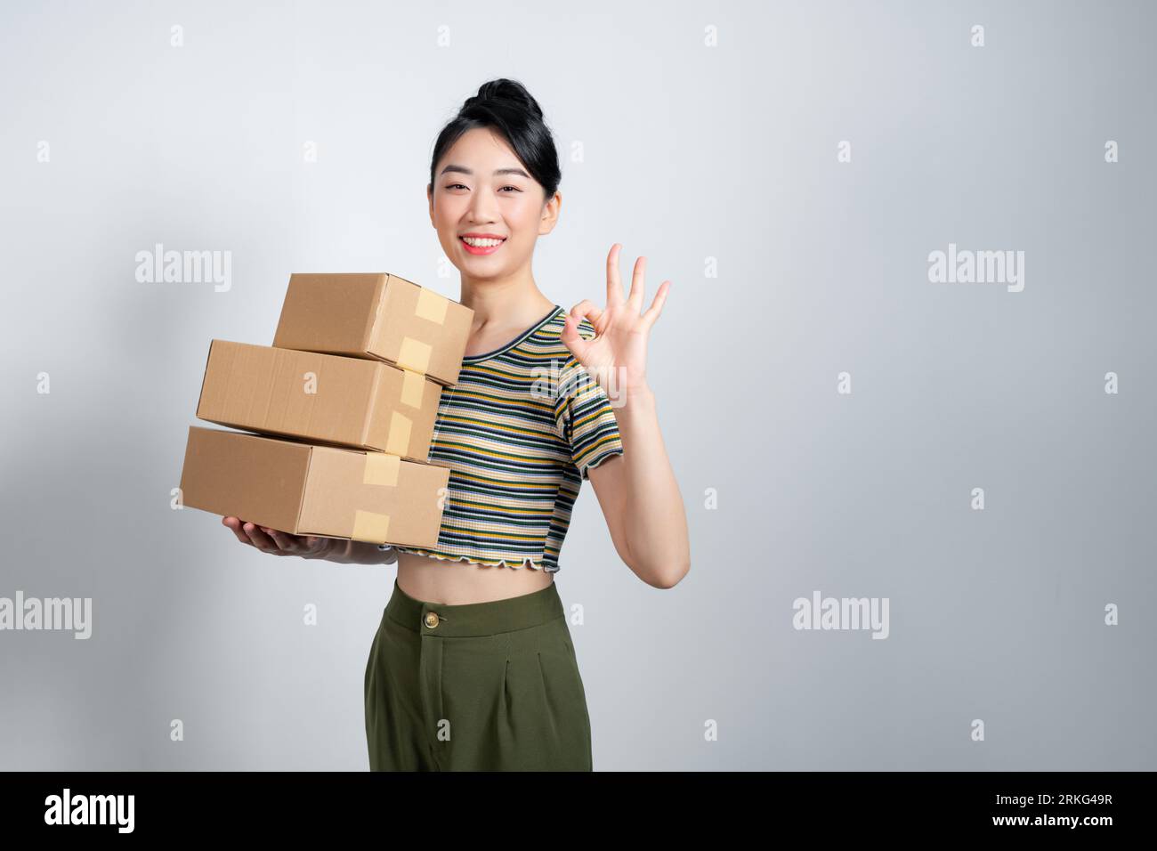 Portrait of young Asian business woman with boxes showing OK sign Stock ...