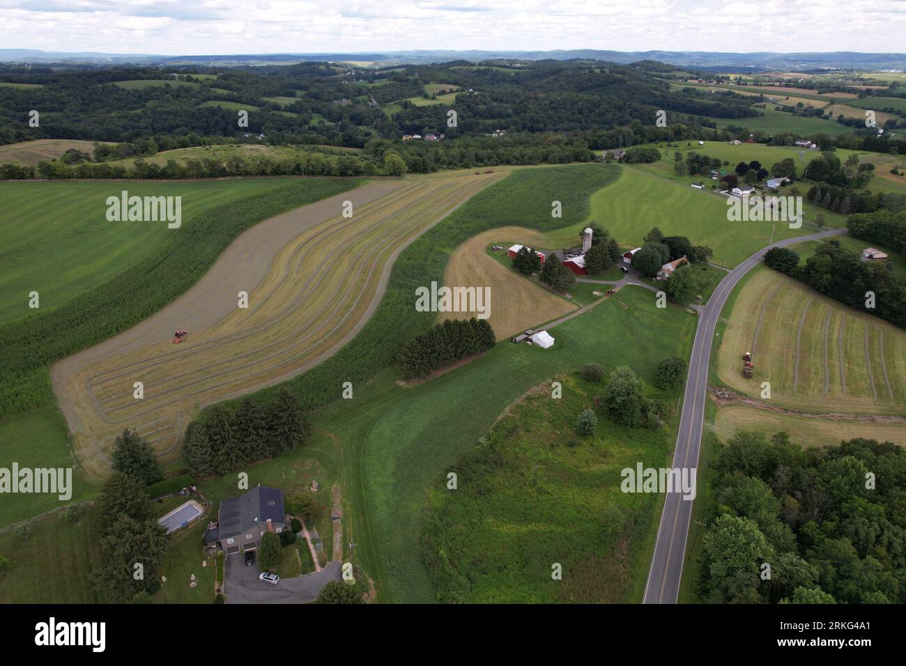 This image depicts a picturesque farm landscape with bright sunshine ...