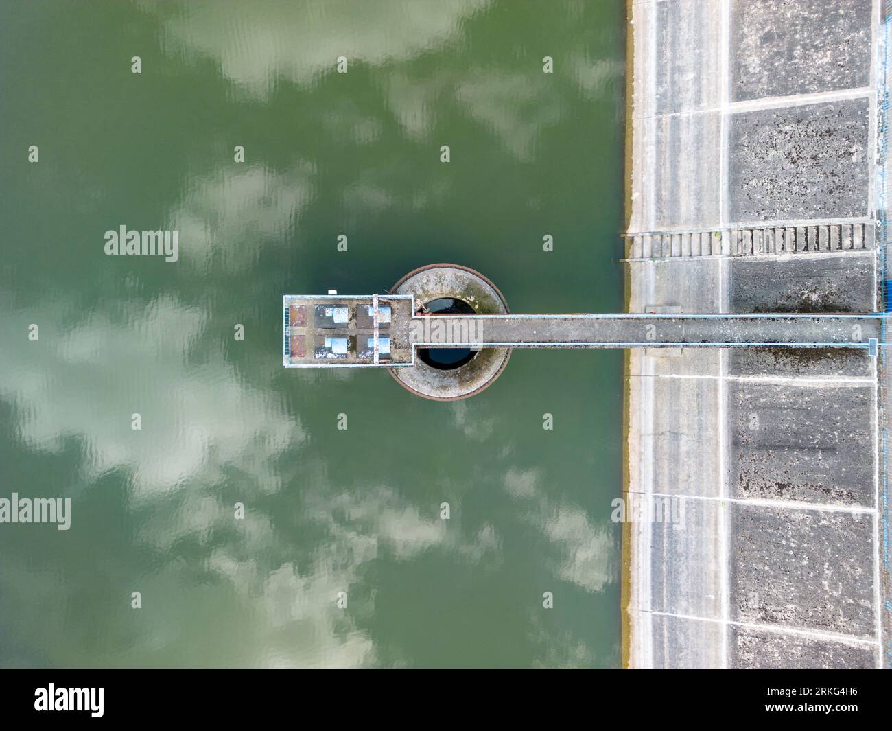 Aerial drone view of a concrete hydroelectric dam with a pump station ...