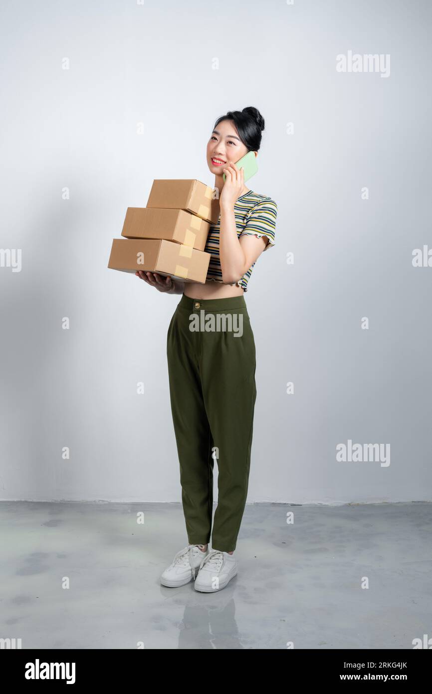 happy young woman calling on her smartphone while standing with a ...