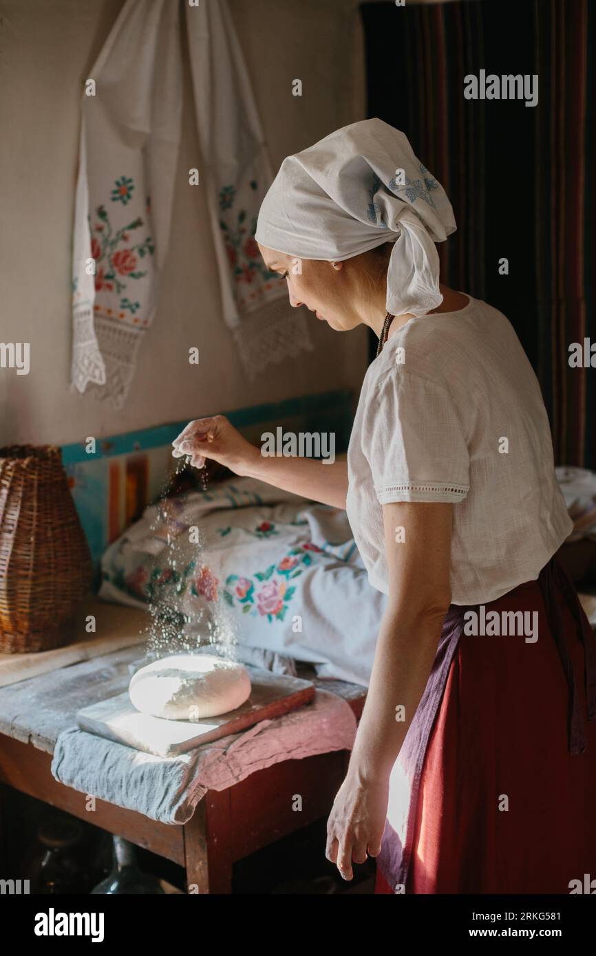 The process of traditional baking of bread at home. A woman in national ...