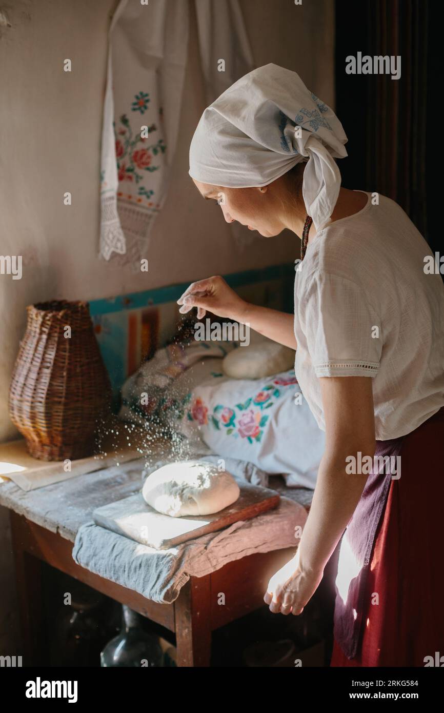 The process of traditional baking of bread at home. A woman in national ...